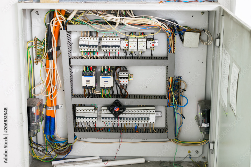 The open electrical box contains many wires, electromagnetic relays and ...