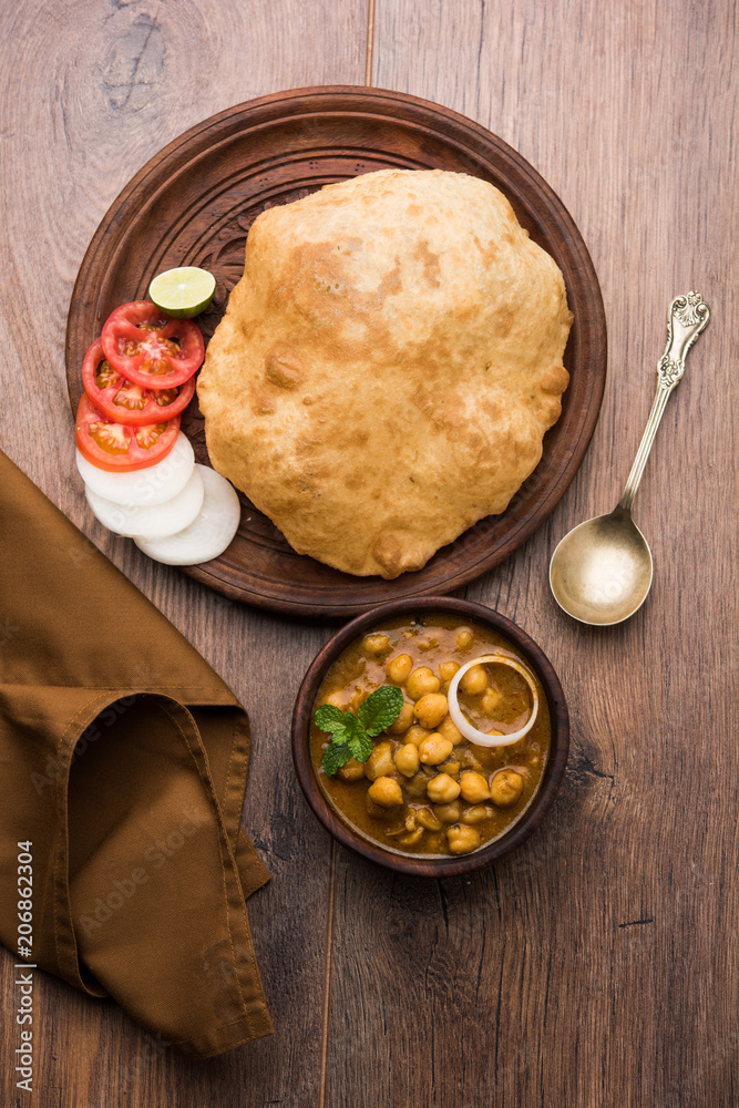 Chole Bhature or Chick pea curry and Fried Puri served in terracotta ...