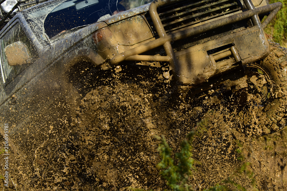 Car with strong chassis and the wheel axle crossing puddle with dirt ...