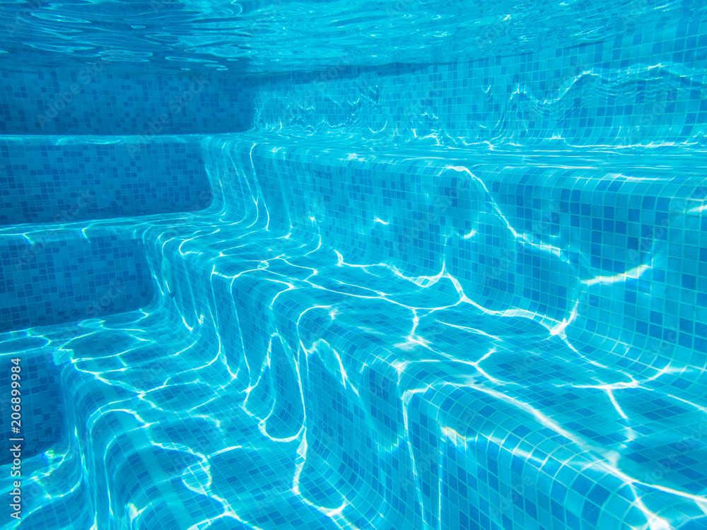underwater image of swimming pool steps with sunlight causing patterns ...