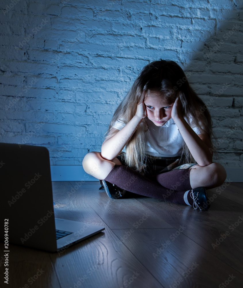 Sad young girl with laptop suffering bullying and harassment online ...