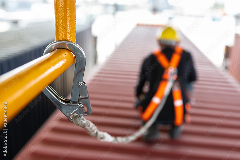 Construction worker wearing safety harness and safety line working on ...