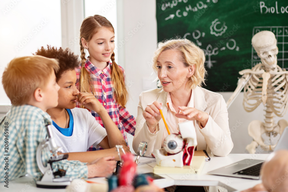 Biology class. Professional female teacher explaining new material ...