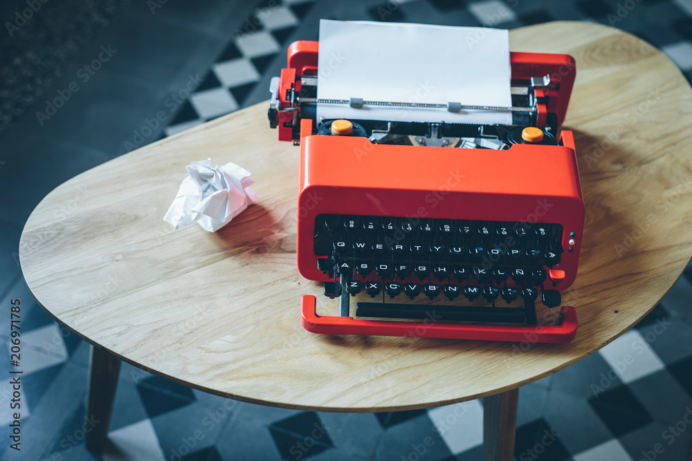Red typewriter and crumpled paper on small table Stock Photo | Adobe Stock