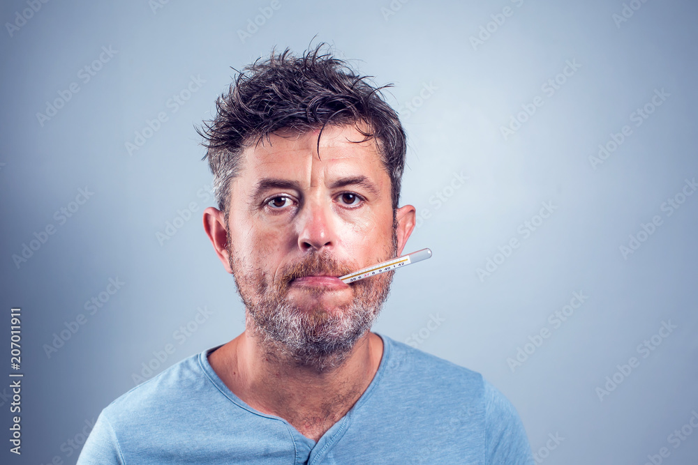 Sick man with thermometer in mouth,looking and worry at thermometer on ...