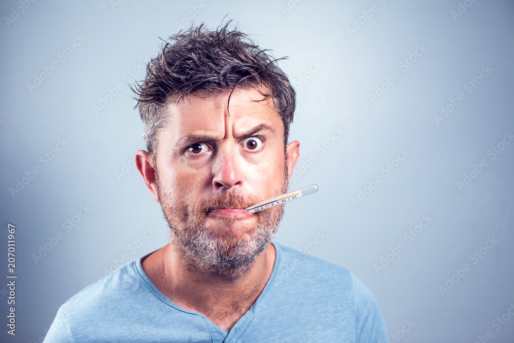 Sick man with thermometer in mouth,looking and worry at thermometer on ...