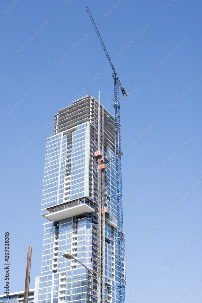 High rise building under construction with tall crane Stock Photo ...