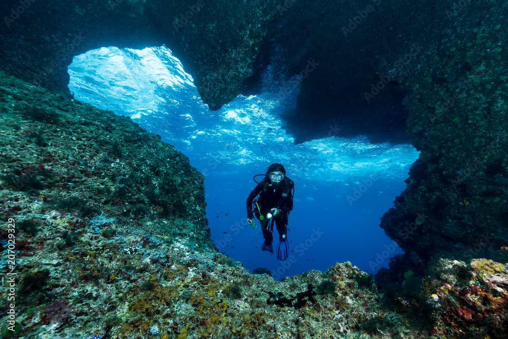 woman diver underwater at the entrance of a cave with sunrays Stock ...
