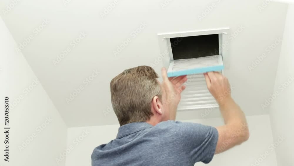 Examining a Small Air Duct with a Flashlight Male inspecting air ducts ...