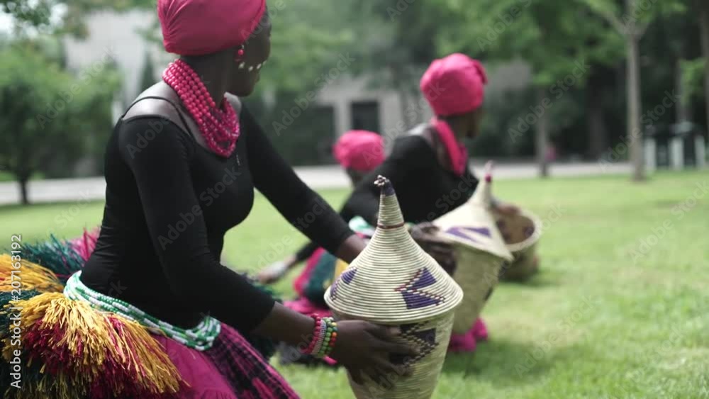 African women are dancing a folk traditional dance on a grass meadow ...
