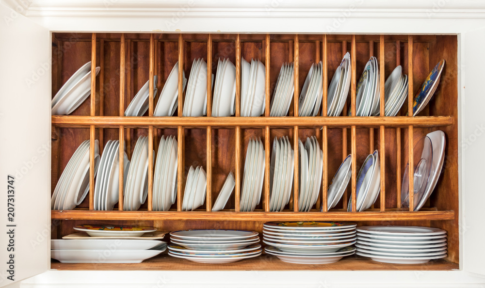 Wooden plate rack inside a vintage cupboard. Stock Photo | Adobe Stock