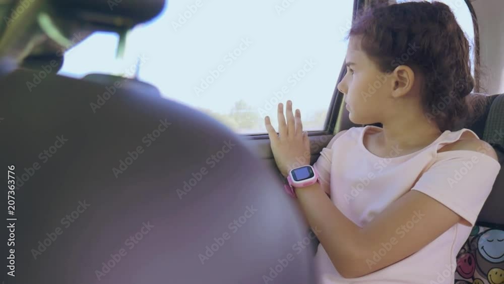 sad girl bored sitting in the car in motion the back seat travel ...