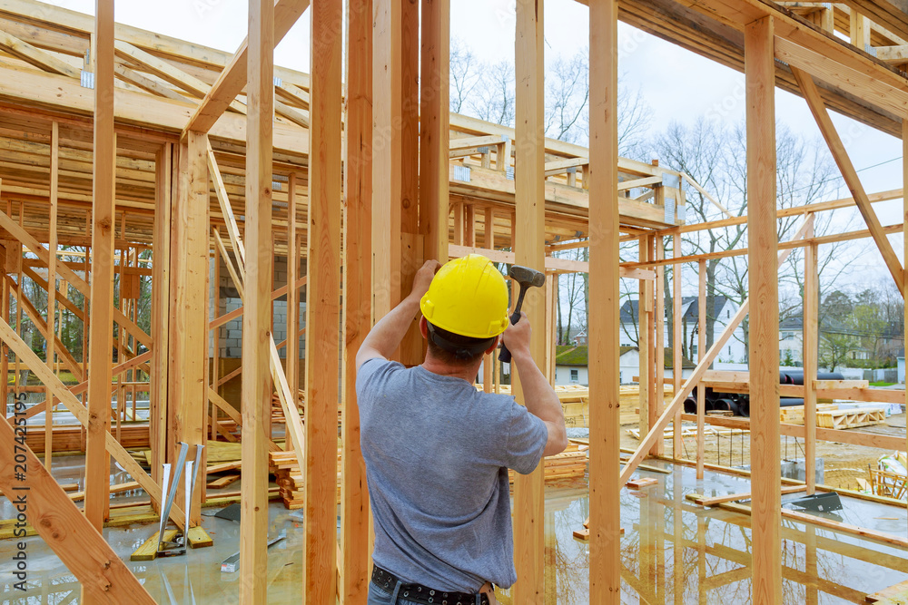 Construction crew working on the roof sheeting of a new, two story ...