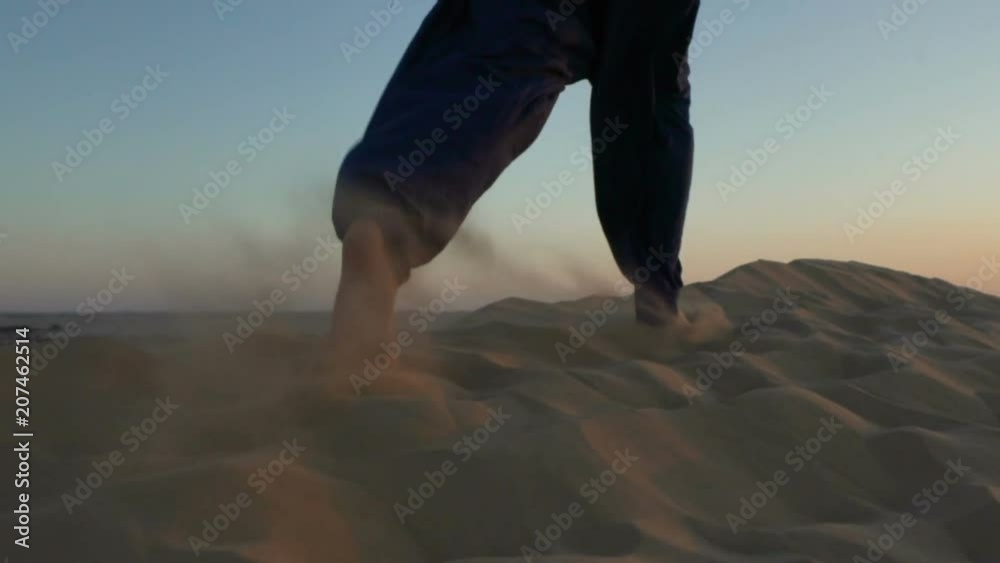 running up a hill sand dune in desert. running in sand dune in desert ...