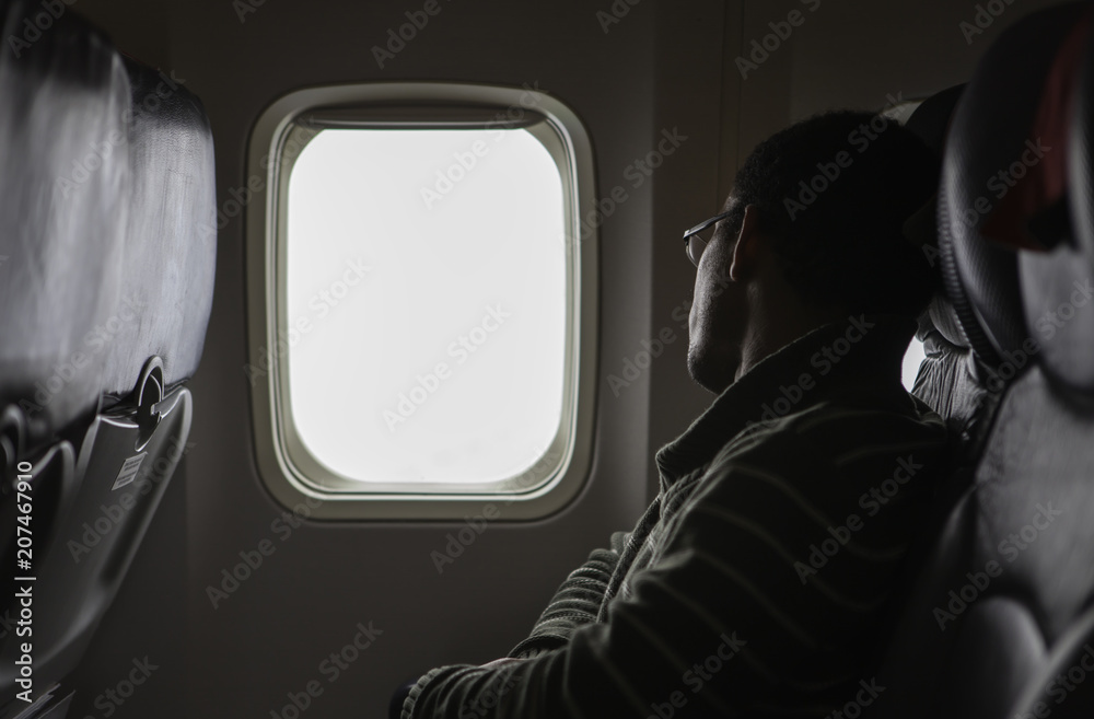 man looking out of the window in airplane. Young man and airplane. Soft ...