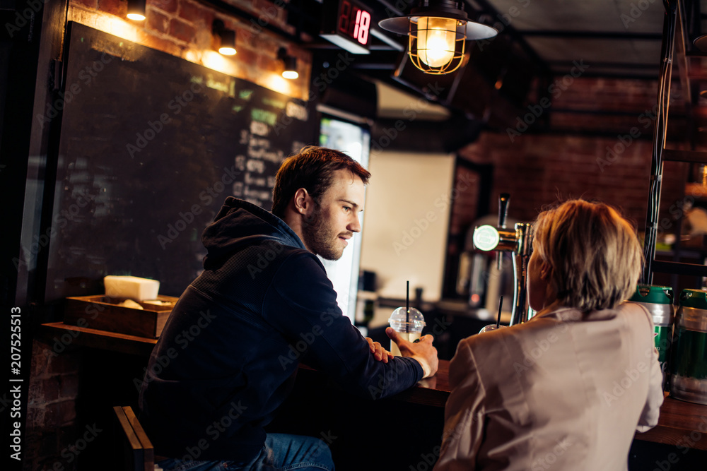 Back view of young couple enjoying romantic moments while talking in a ...