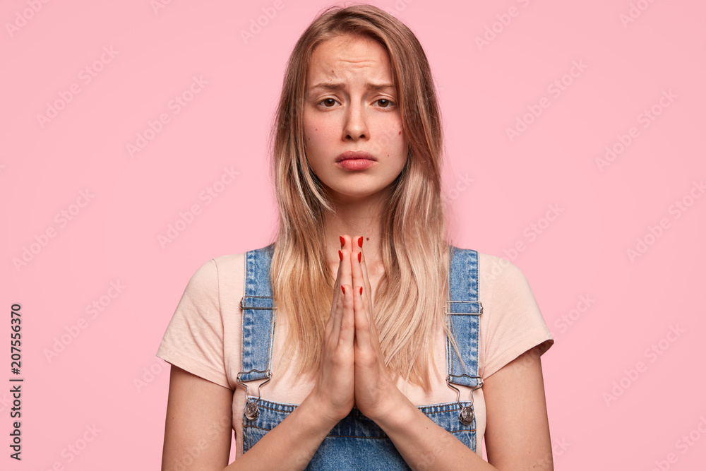 Photo of attractive female apologizes with sorrowful expression, stands ...