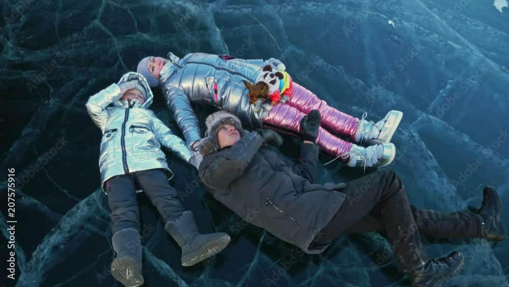 Family is having fun on beautiful ice in cracks. Father mother son and ...
