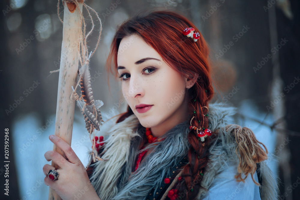 Beautiful girl with long braids in a winter forest. A witch from a ...