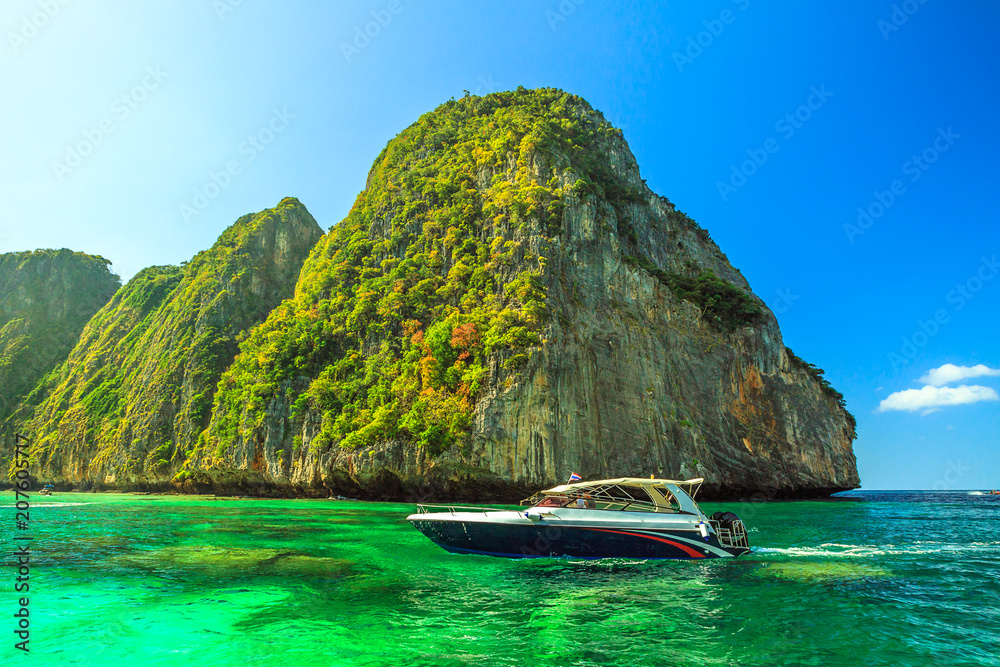 Motorboat enters the scenic lagoon of popular Maya Bay Beach surrounded ...