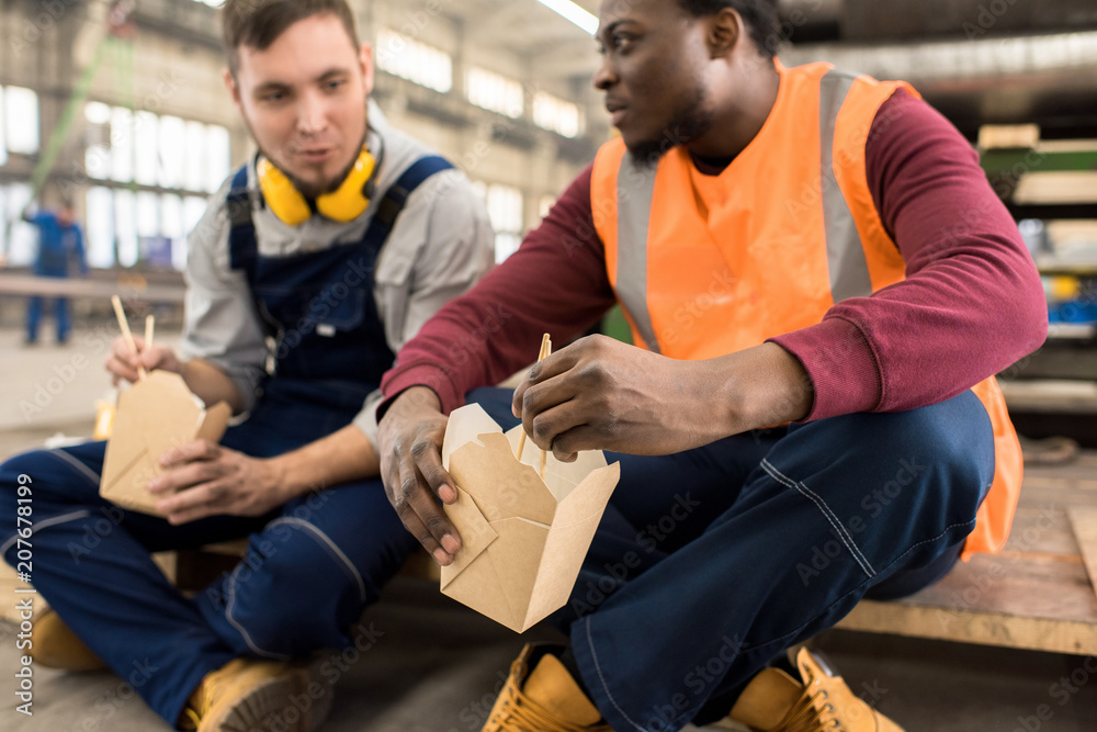 Machine operators wearing overalls taking break from work: they ...