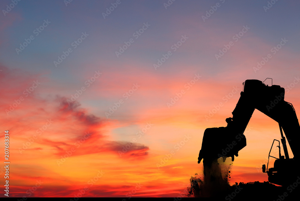 silhouette of Excavator loader at construction site with raised bucket ...