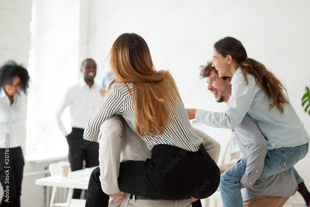 Back view of positive colleagues having fun together at office, doing ...