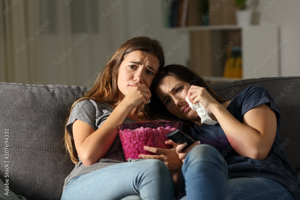 Two sad friends crying watching tv in the night Stock Photo | Adobe Stock