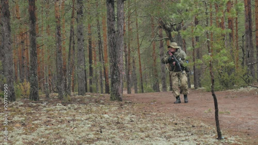 Soldiers in camouflage with combat weapons make their way outside the ...