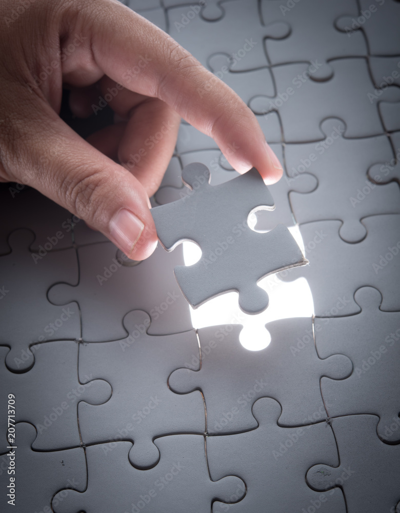 Hand embed missing puzzle piece into place with light glow,success ...