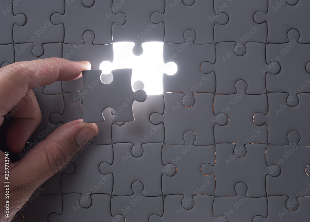 Hand embed missing puzzle piece into place with light glow,success ...