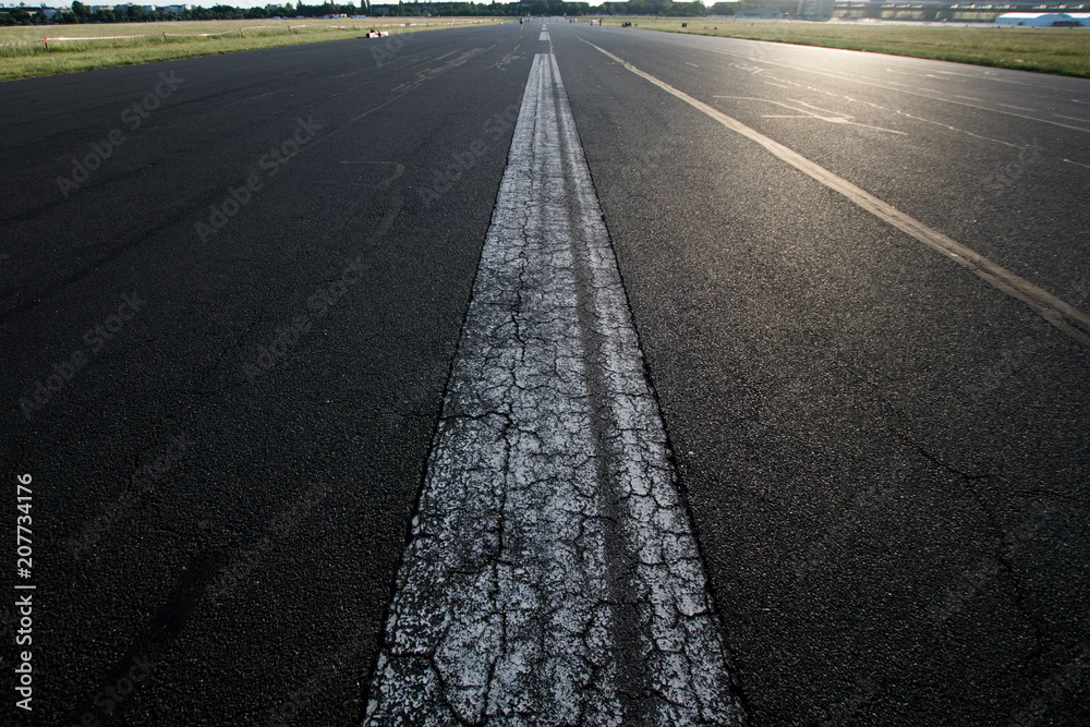 Asphalt road with white strip of the central lane in perspective ...