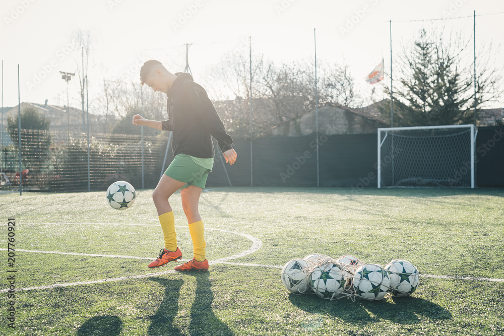 Football player practising on football pitch Stock Photo | Adobe Stock