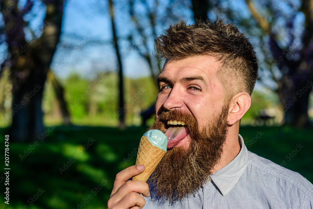 Chilling concept. Man with long beard licks ice cream, close up ...
