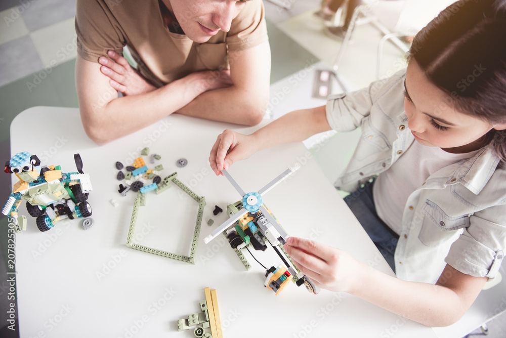 Top view happy kid and glad man creating modern toy from constructor ...