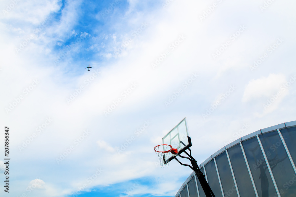 Basketball court on rooftop, clear blue sky with white cloud, airplane ...