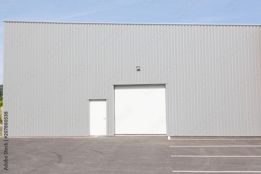 grey Warehouse building with blue sky and white door Stock Photo ...