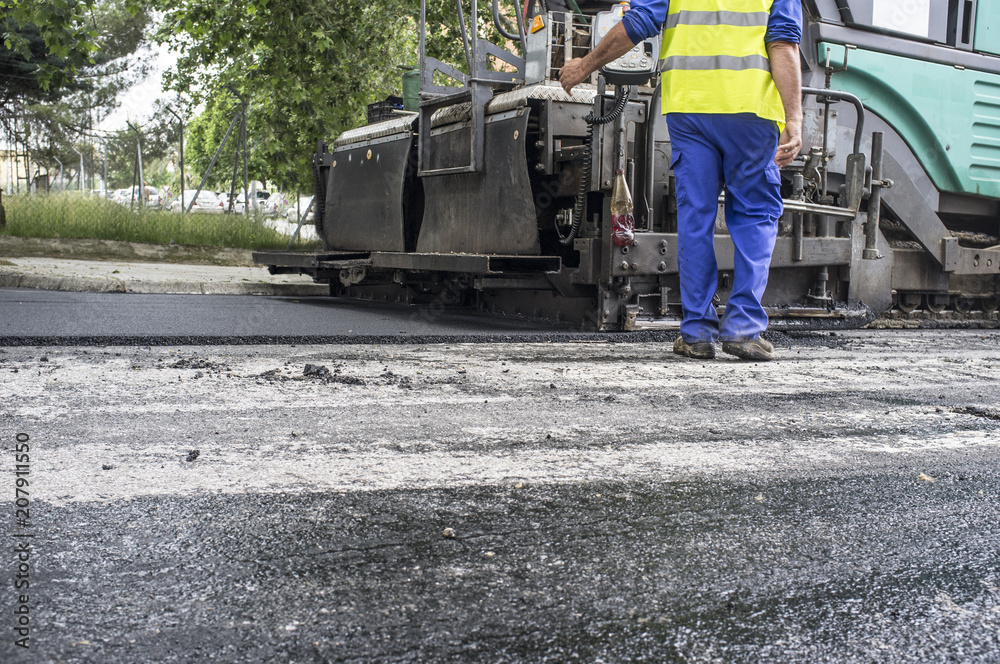 Paving applicator machine or paver with worker Stock Photo | Adobe Stock
