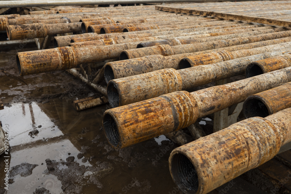 Oil drill pipe.Well Drilling.Laid out drilling pipes at a well site ...