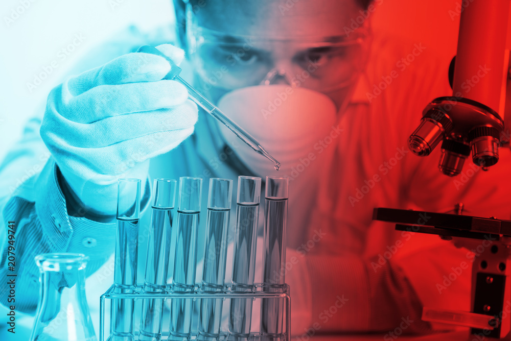 scientist checking sample cemical in test tube at working table ...