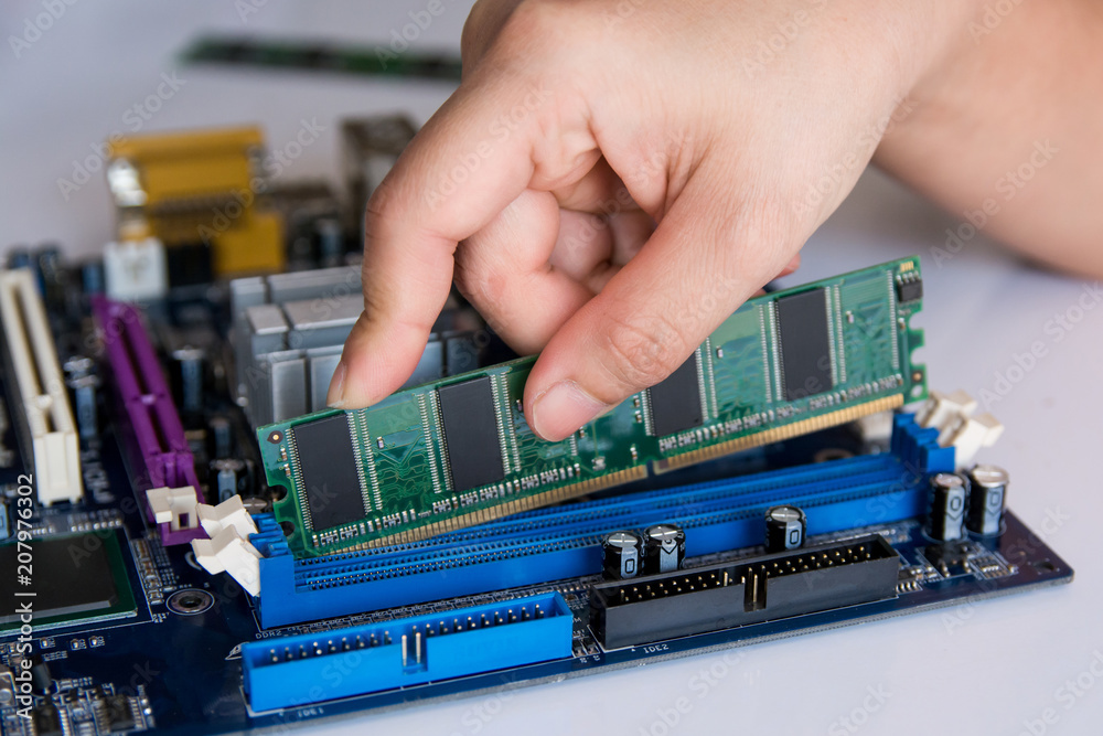 Technician installing RAM stick (random access memory) to socket on ...