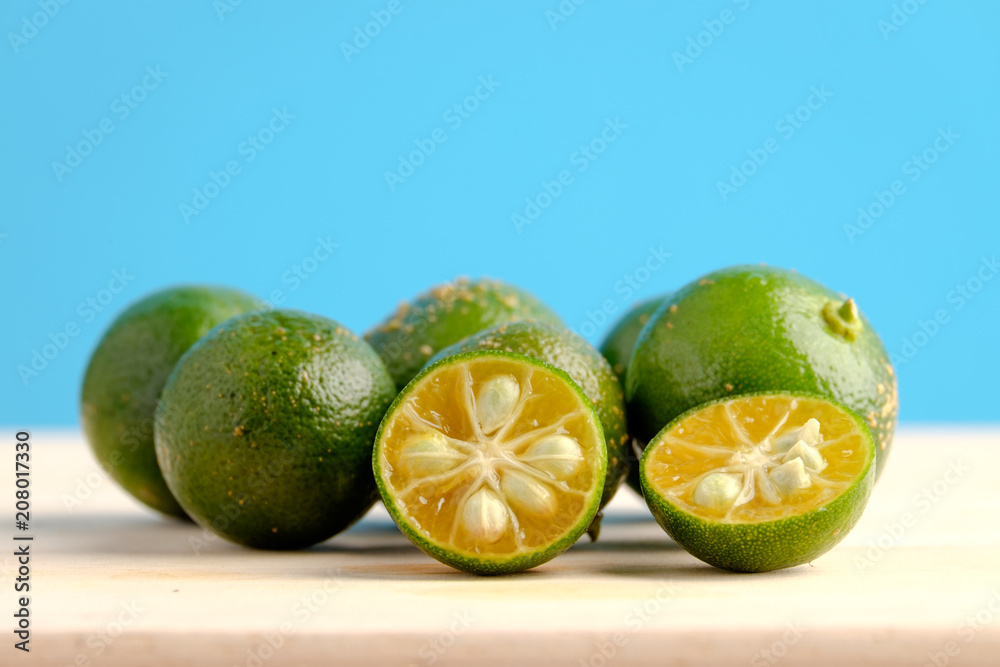 Calamansi on wooden table and blue background Stock Photo | Adobe Stock