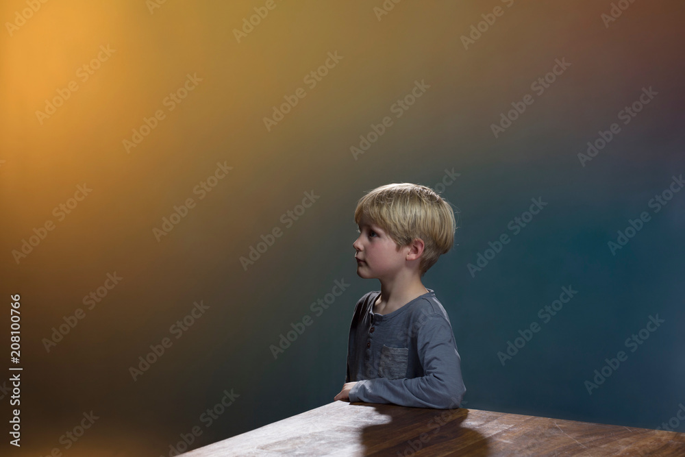 Boy at table, gold and blue background Stock Photo | Adobe Stock