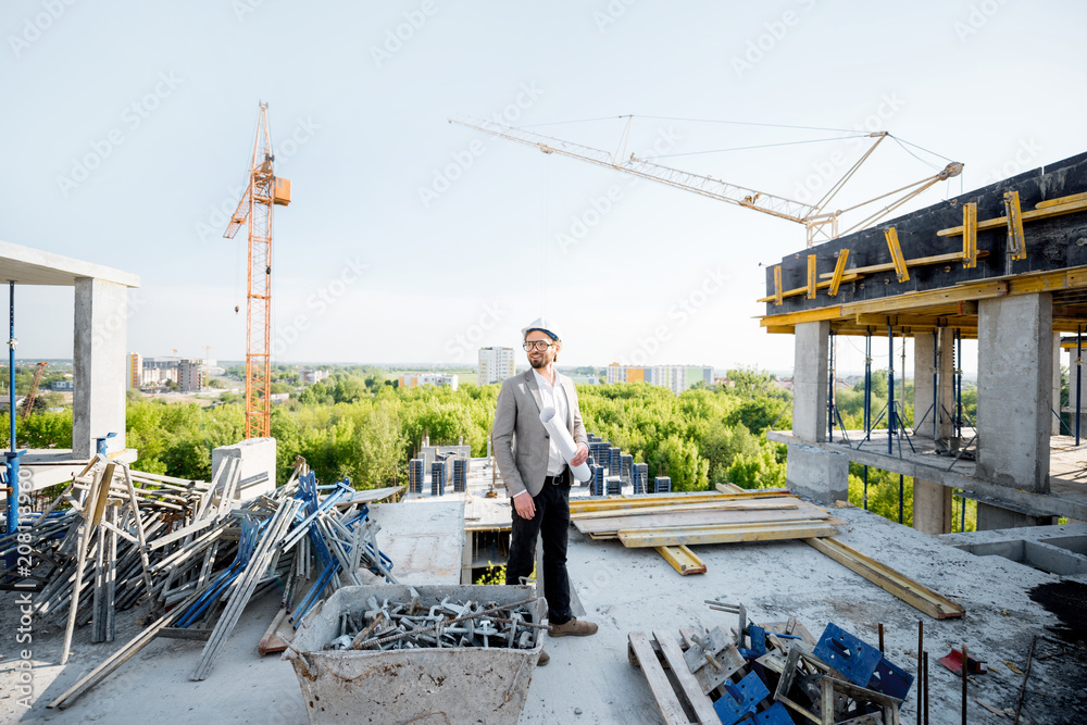 Engineer checking the construction process standing with house drawings ...