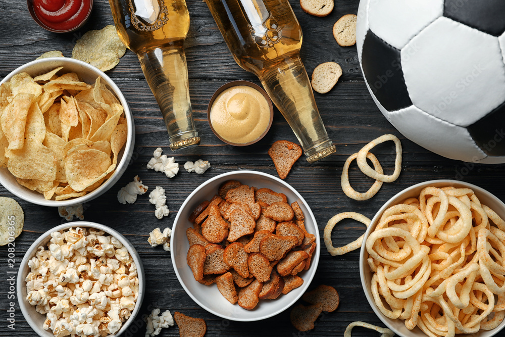 Table full of tasty snacks and beer prepared for watching football on ...