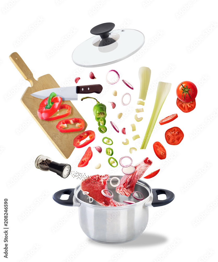 Set of ingredients and meat flying and falling into cooking pot for ...