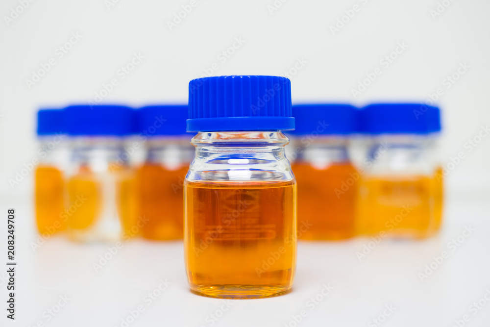 Broth media in the laboratory bottles placed on the white table and ...