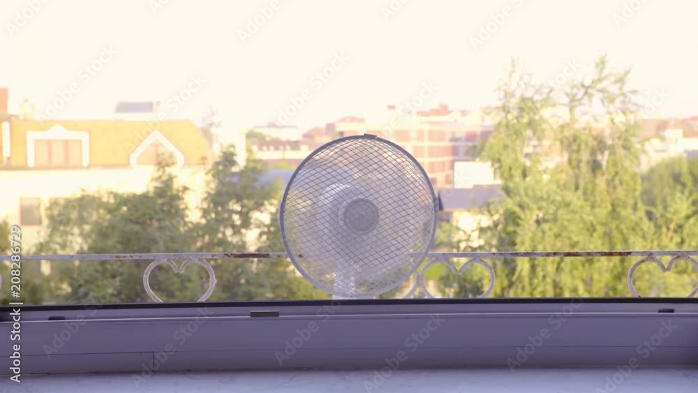 Fan chilling inside the flat from window shelf 4K. Long shot of fan ...