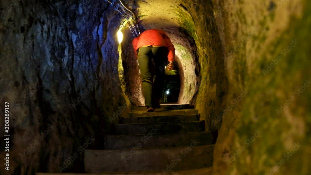 Tourist with lights exploring caves in Kaymakli ancient multi-level ...
