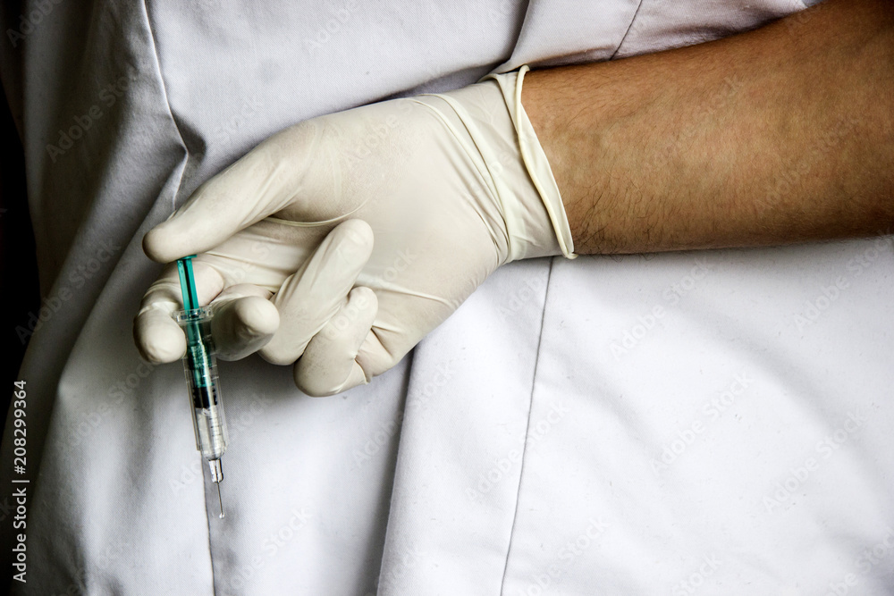 Doctor hand in white glove hold syringe with preparation jet from the ...
